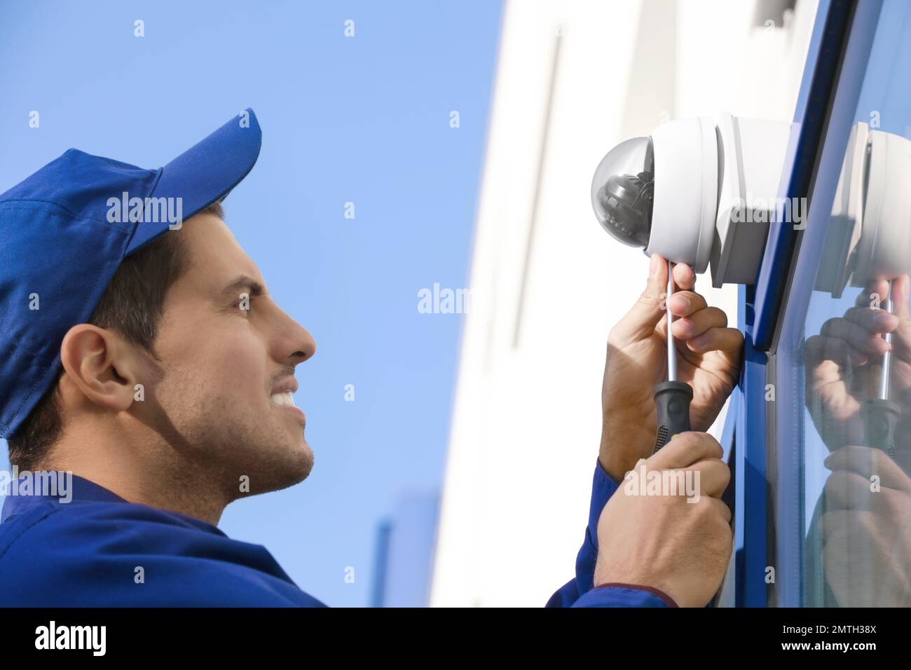 Technician installing CCTV camera on wall outdoors Stock Photo - Alamy