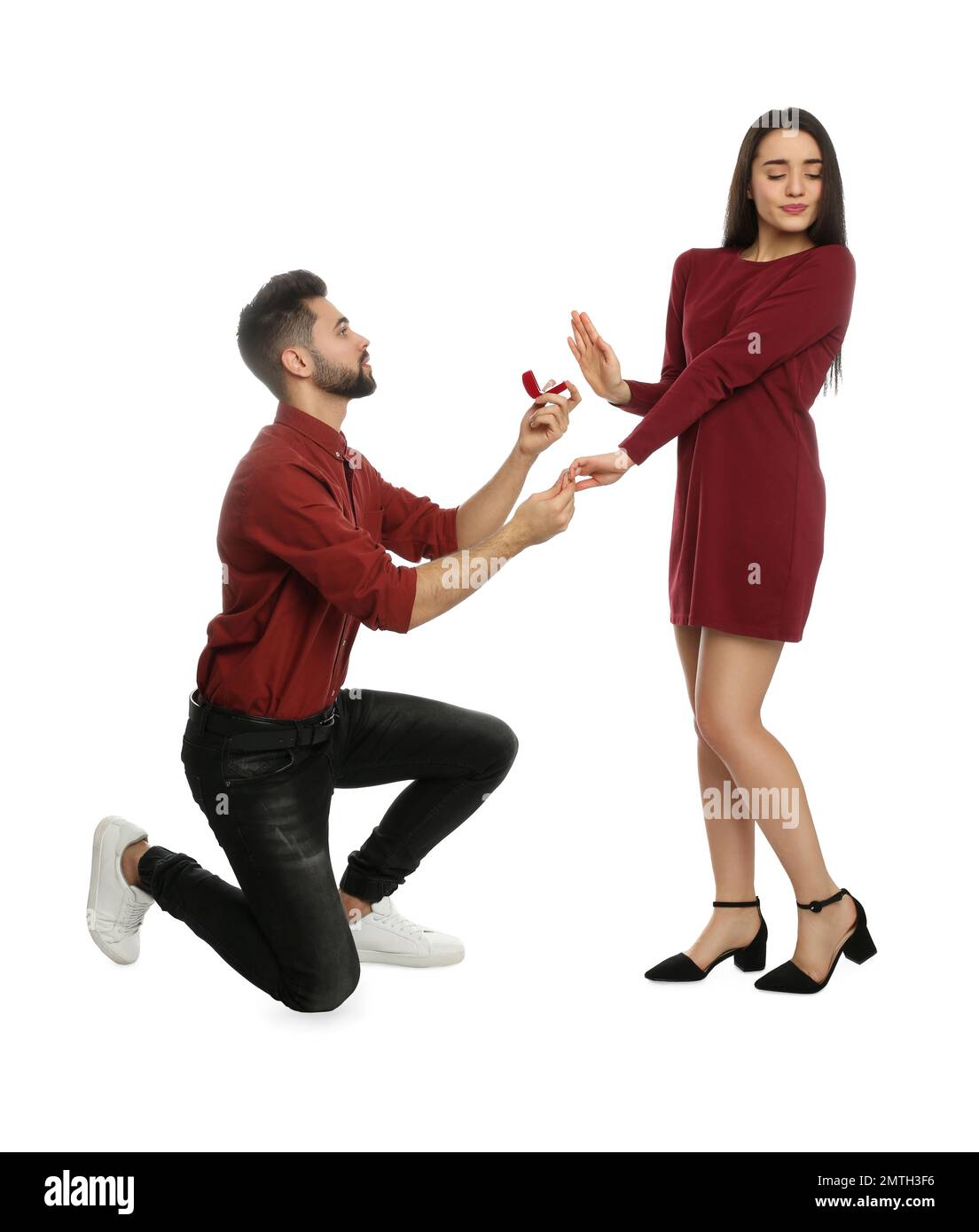 Young woman rejecting engagement ring from boyfriend on white ...