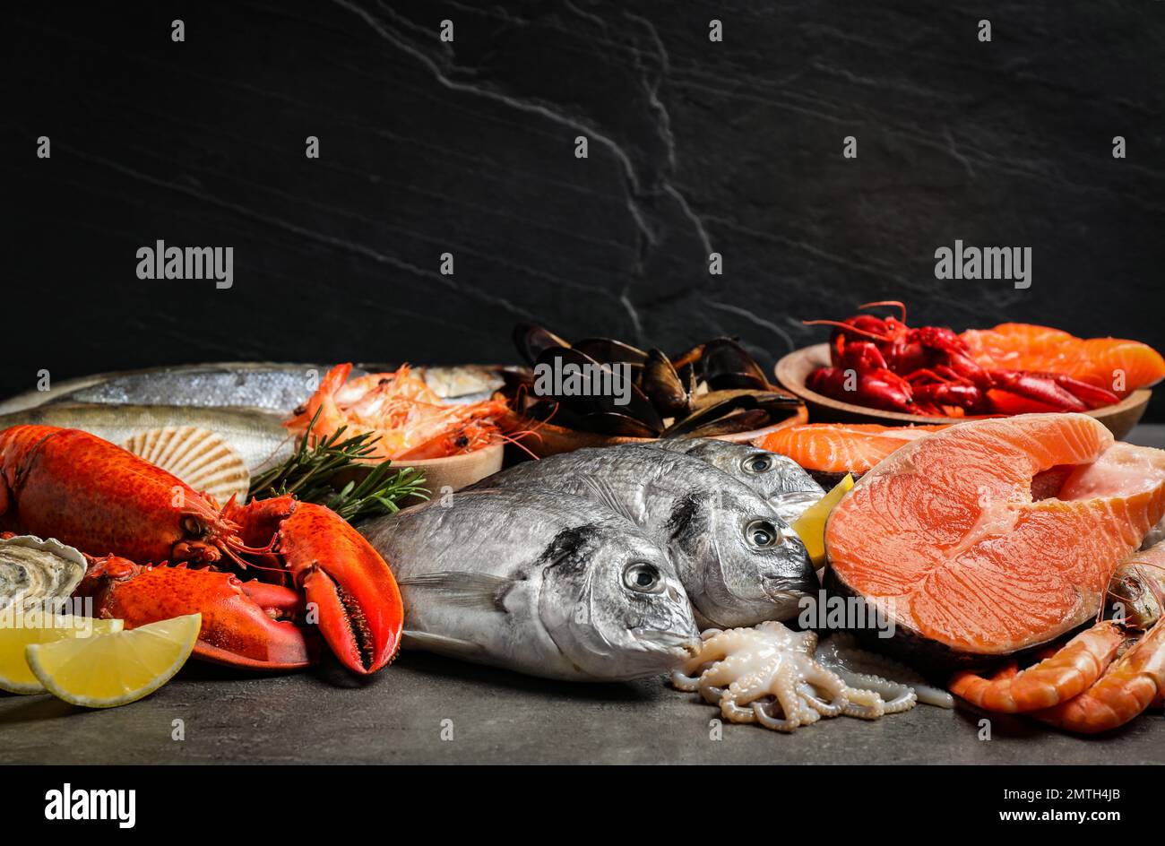 Fresh fish and different seafood on grey table Stock Photo - Alamy