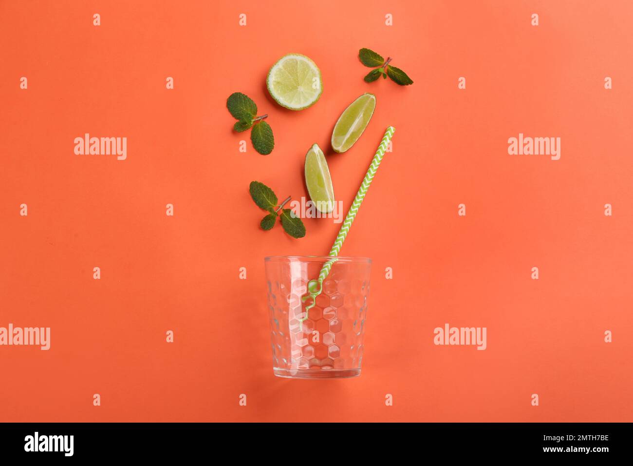 Creative lemonade layout with lime slices and mint on coral background ...