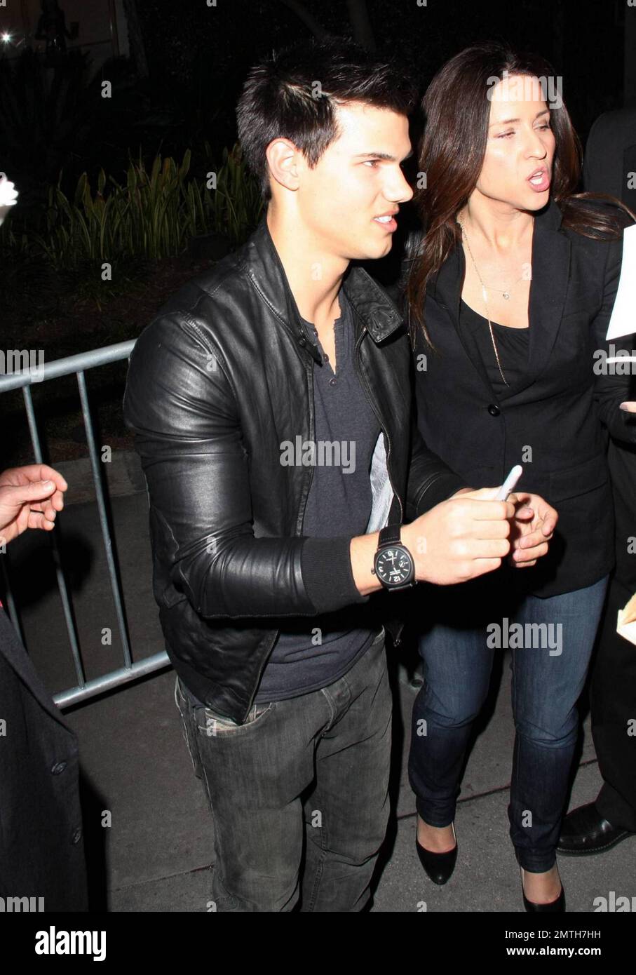 Taylor Lautner poses for photos and signs autographs as he arrives at ...