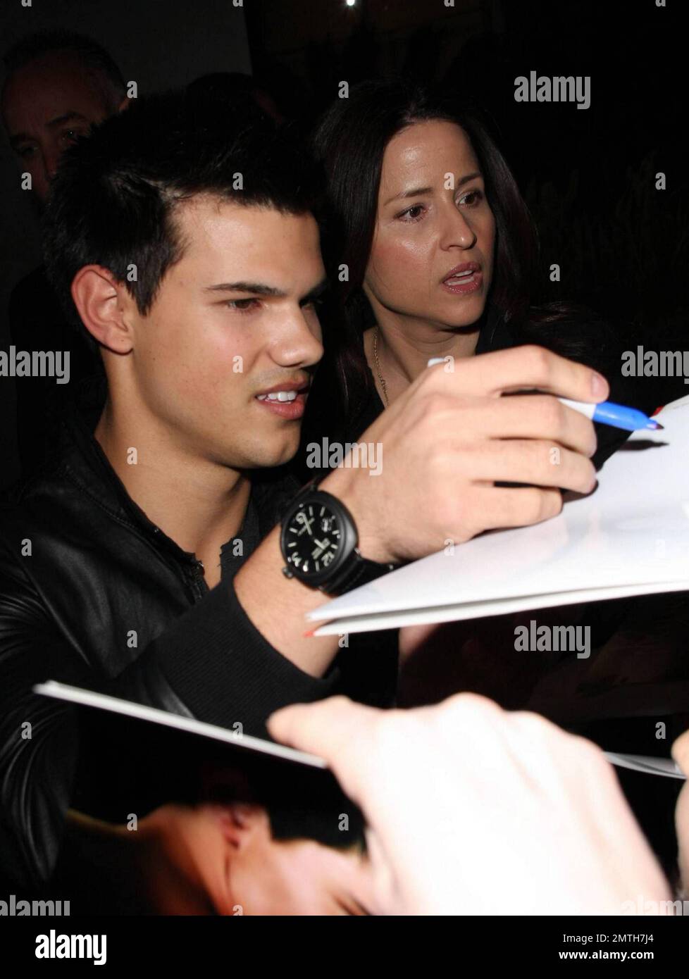 Taylor Lautner poses for photos and signs autographs as he arrives at ...
