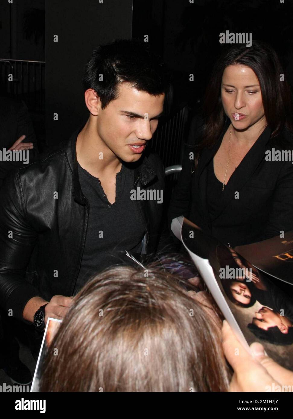 Taylor Lautner poses for photos and signs autographs as he arrives at ...
