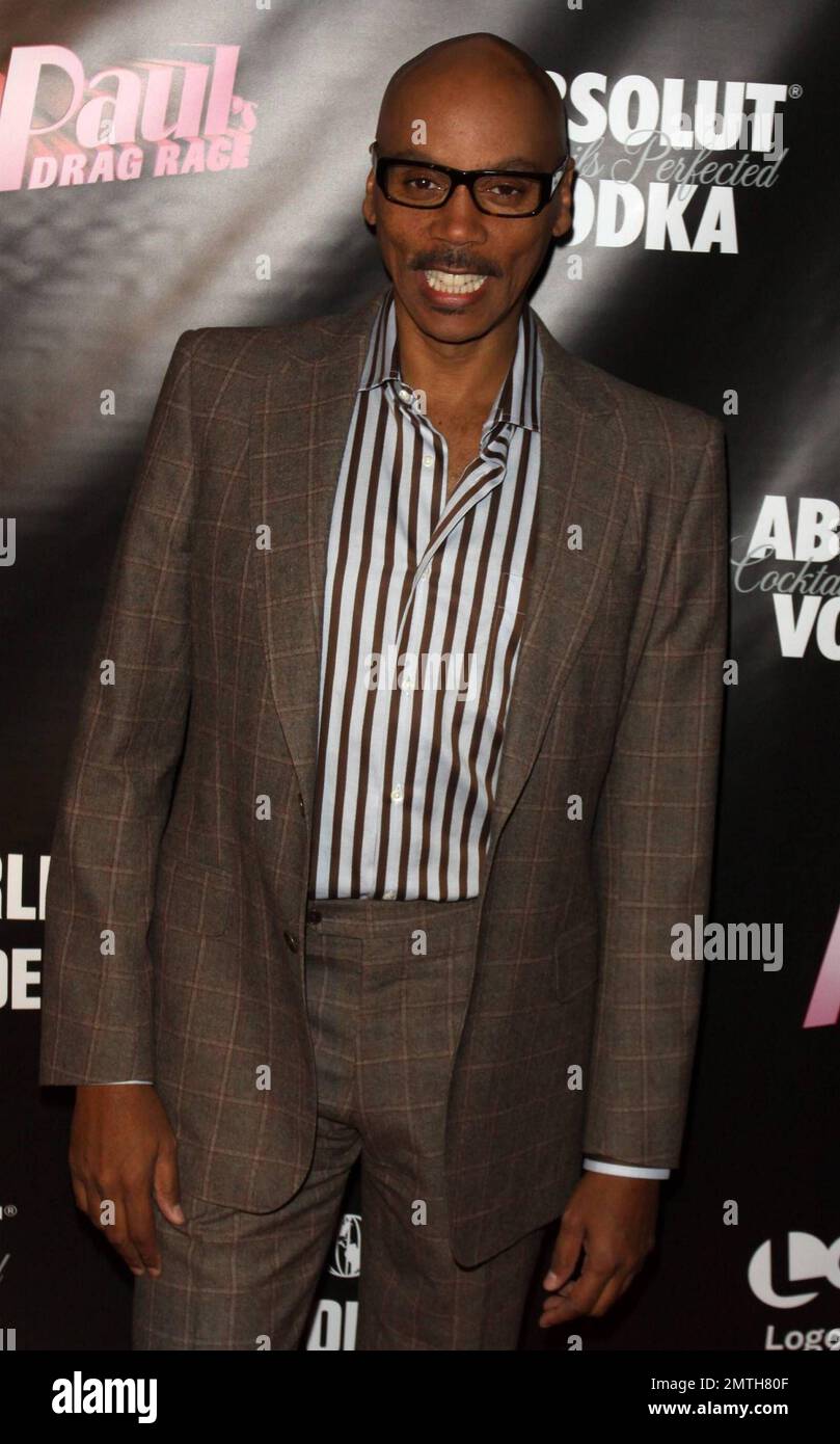 RuPaul looks sharp in a brown suit with striped shirt and glasses, a ...