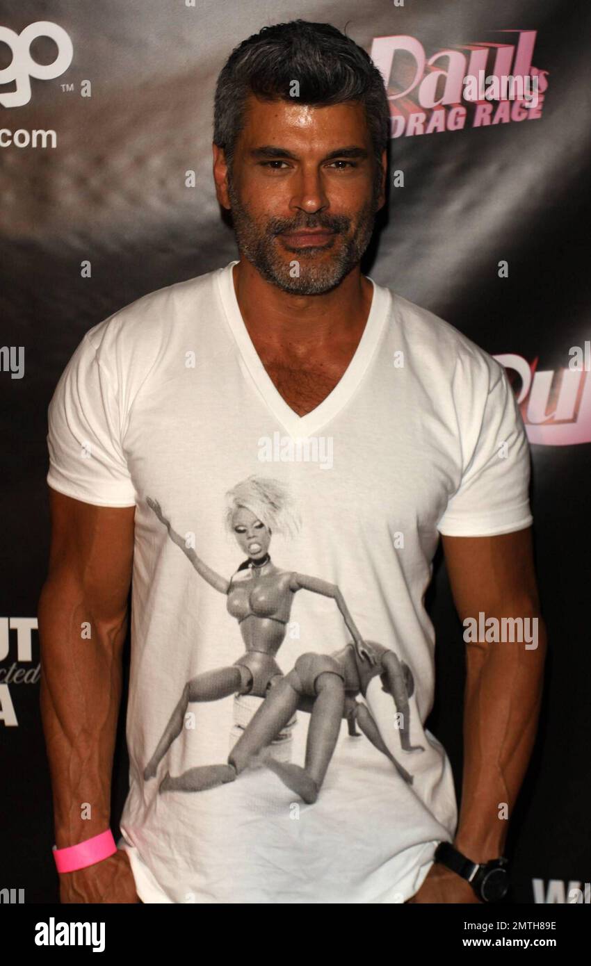 Photographer Mike Ruiz wears a comical shirt and poses for photographers on the red carpet at ...