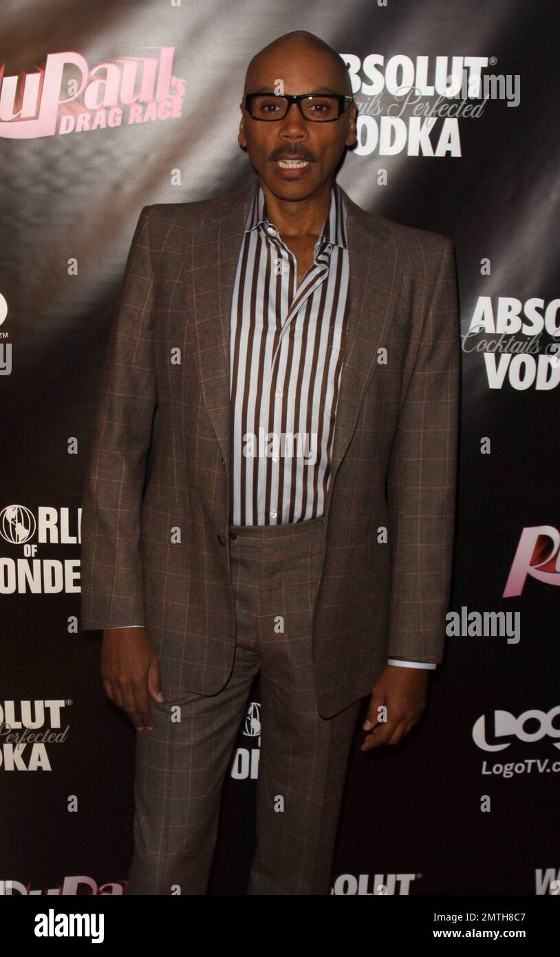 RuPaul looks sharp in a brown suit with striped shirt and glasses, a ...