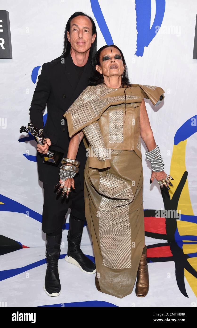 Rick Owens, left, poses in the press room holding the Geoffrey Beene ...