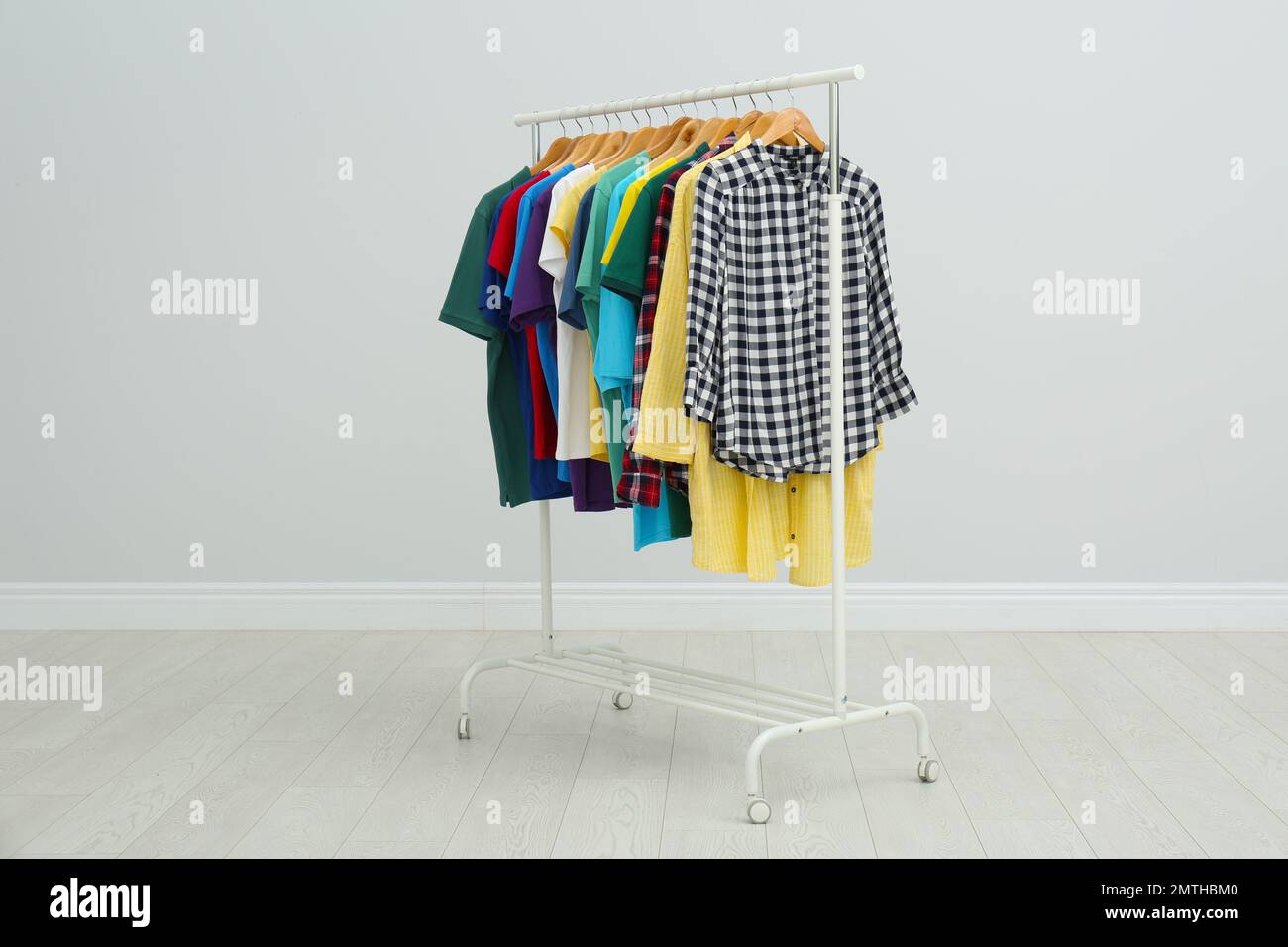 Rack with bright stylish clothes in room Stock Photo - Alamy