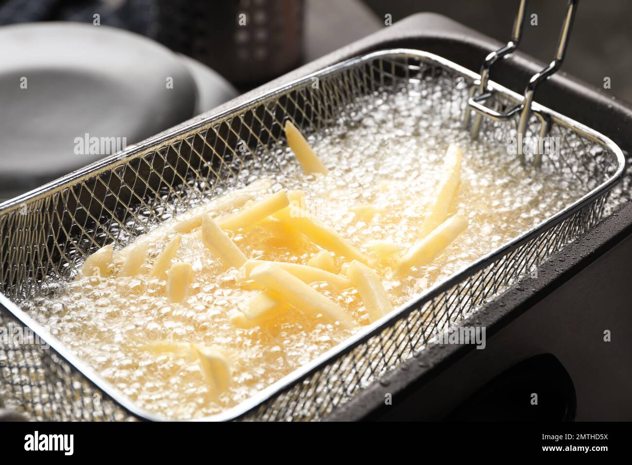 Cooking delicious french fries in hot oil Stock Photo - Alamy