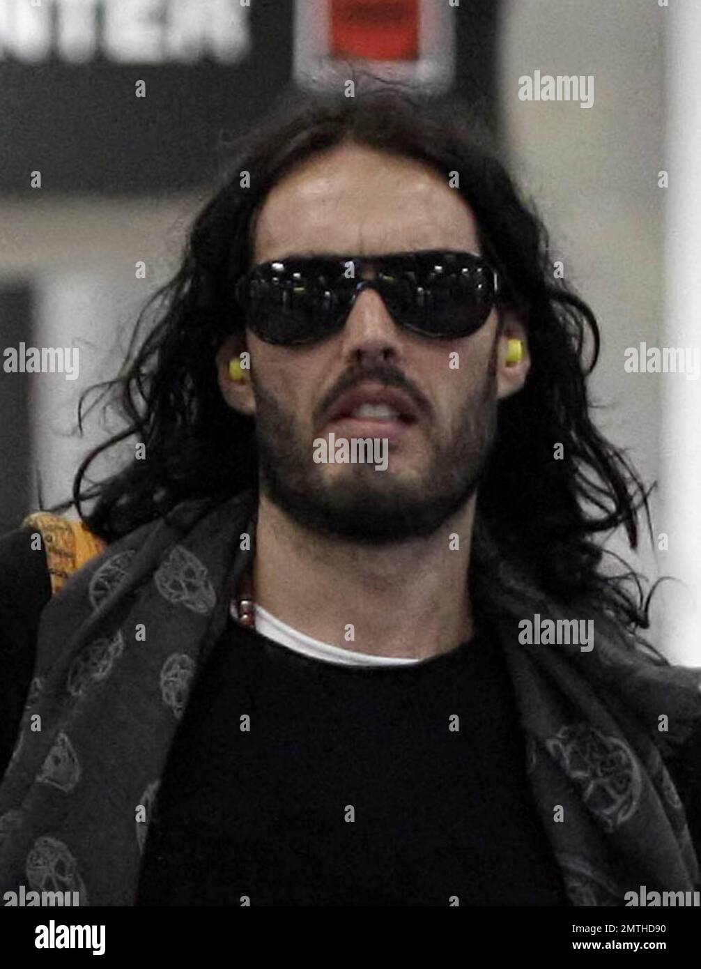 EXCLUSIVE!! English actor Russell Brand wears ear plugs as he arrives ...