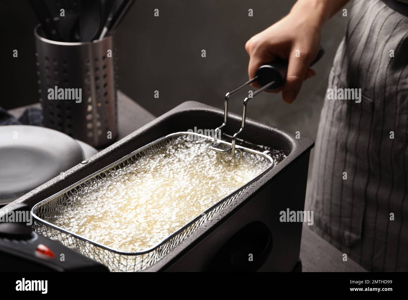 Chef cooking delicious french fries in hot oil, closeup Stock Photo - Alamy