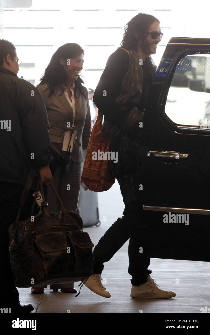 EXCLUSIVE!! English actor Russell Brand wears ear plugs as he arrives ...