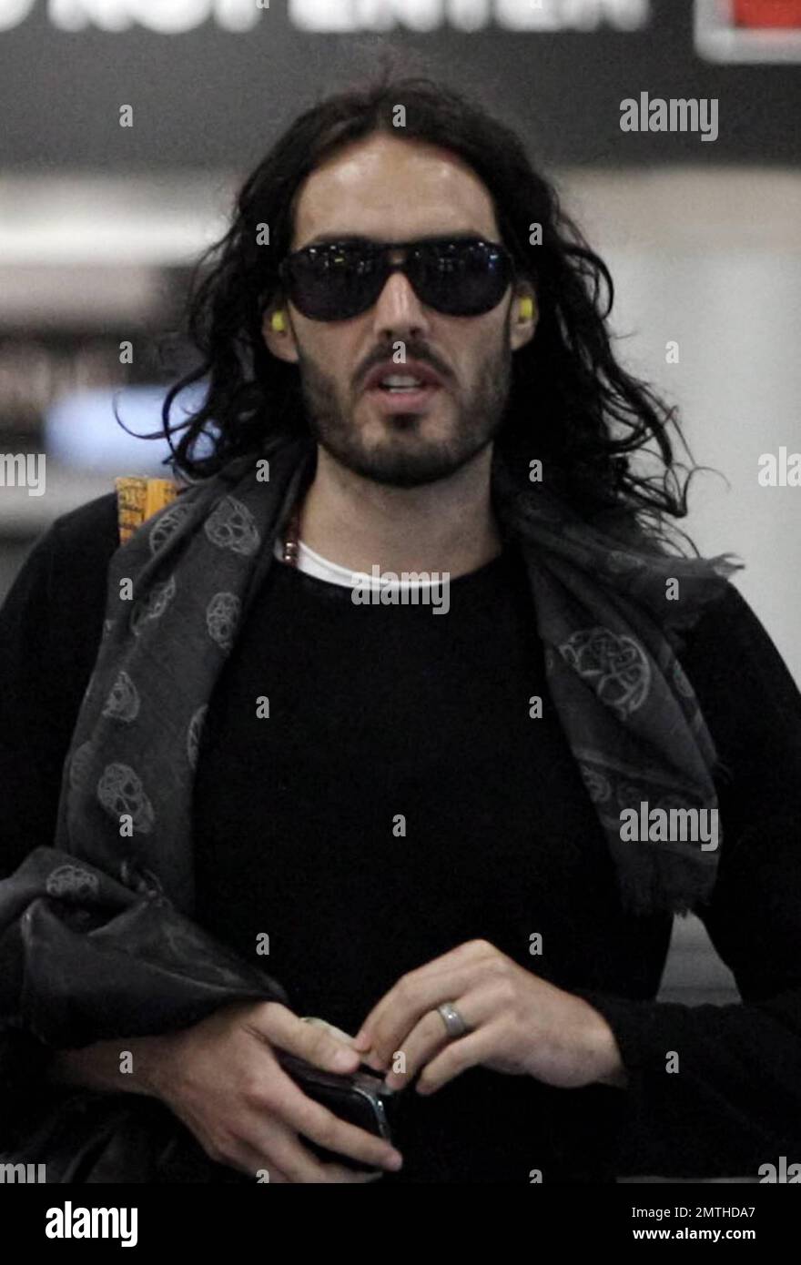 EXCLUSIVE!! English actor Russell Brand wears ear plugs as he arrives ...
