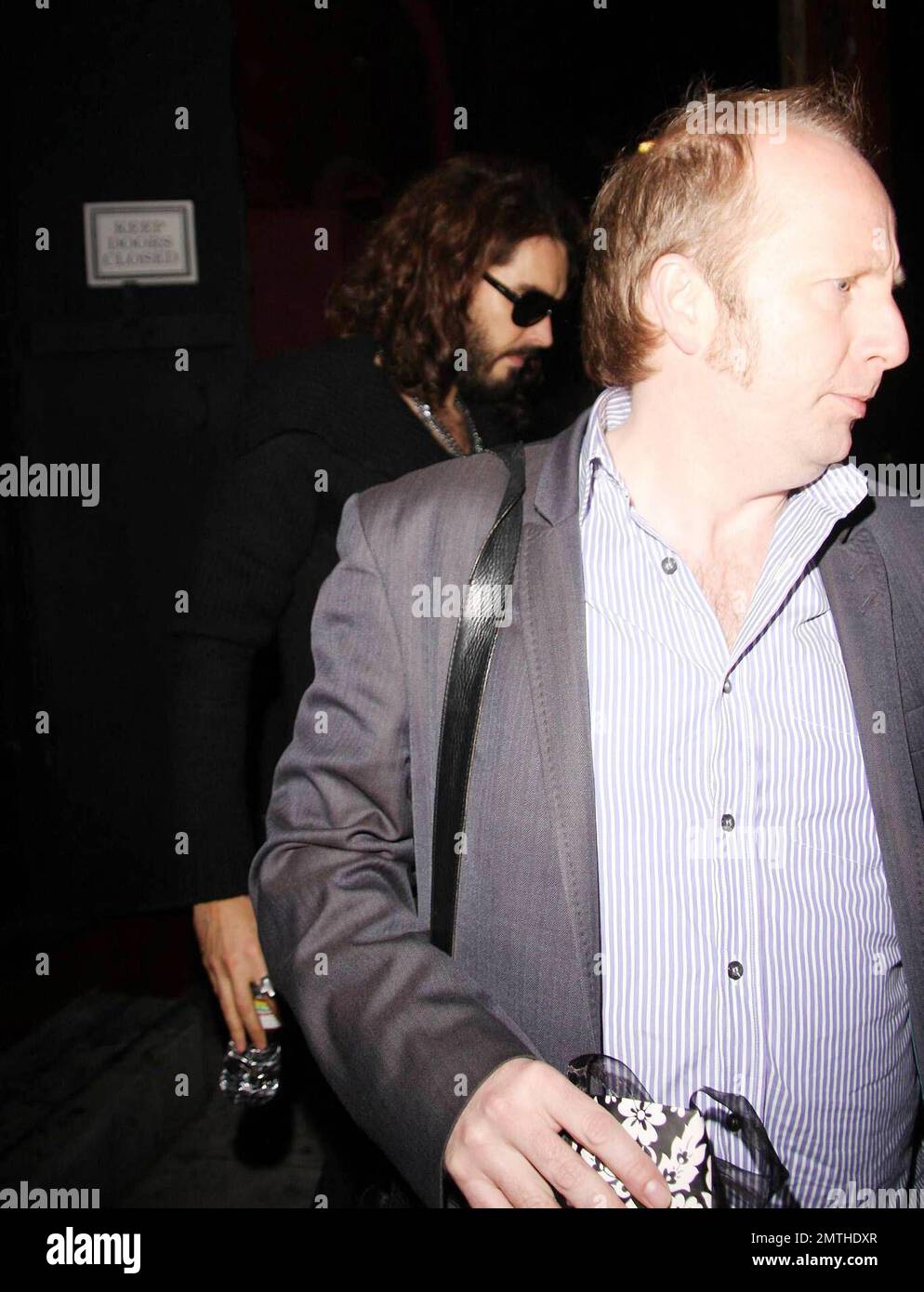 Disgraced UK comedian Russell Brand leaves via the back door of the ...