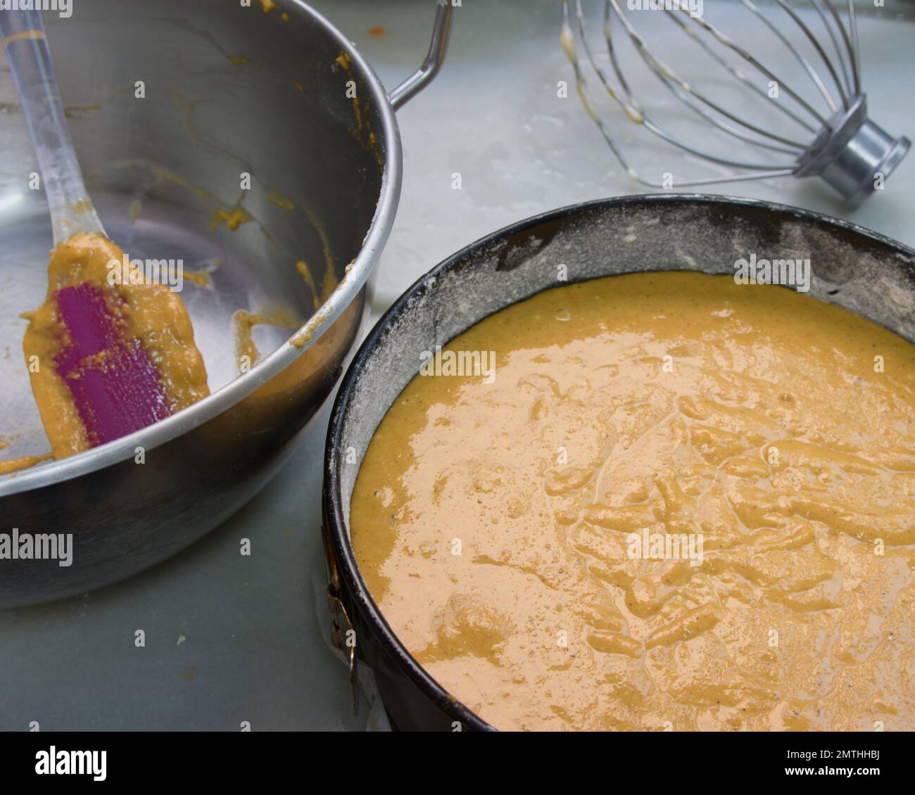 Finishing the preparation of a carrot cake, in the foreground is a bowl ...