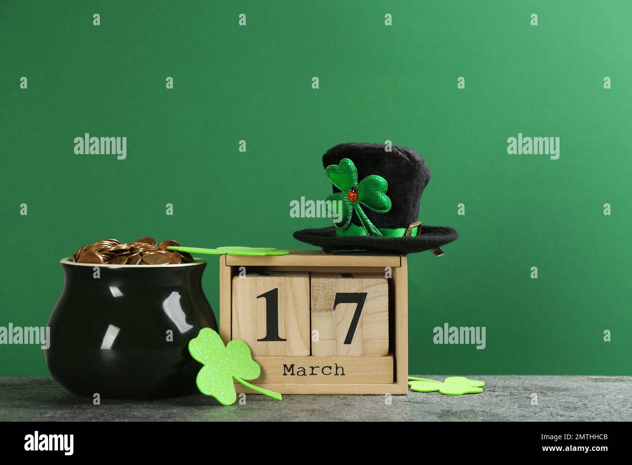 Composition pot of gold coins and wooden block calendar on grey stone ...
