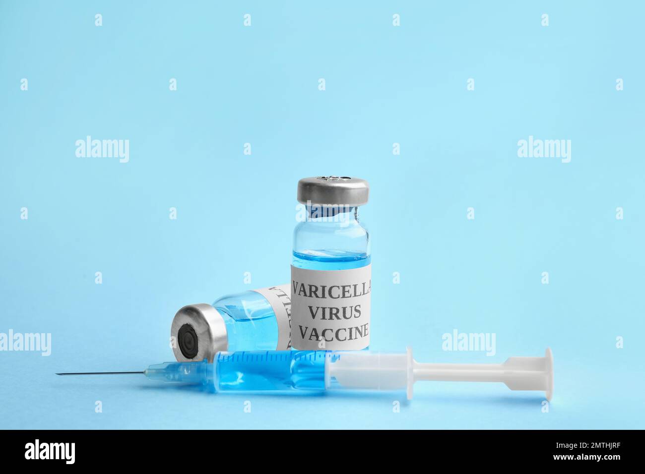 Chickenpox vaccine and syringe on light blue background. Varicella ...