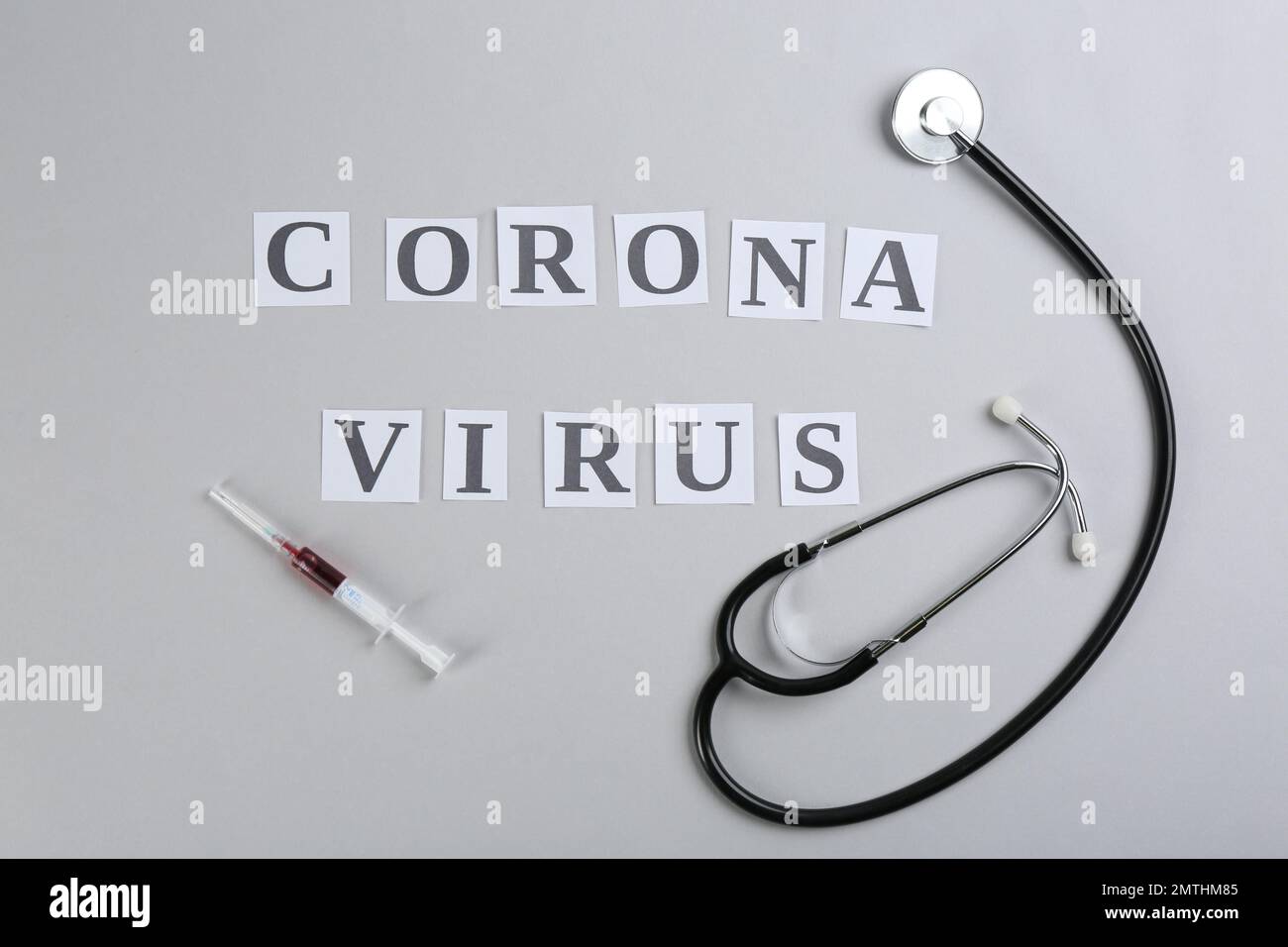 Flat lay composition with words CORONA VIRUS, stethoscope and syringe ...