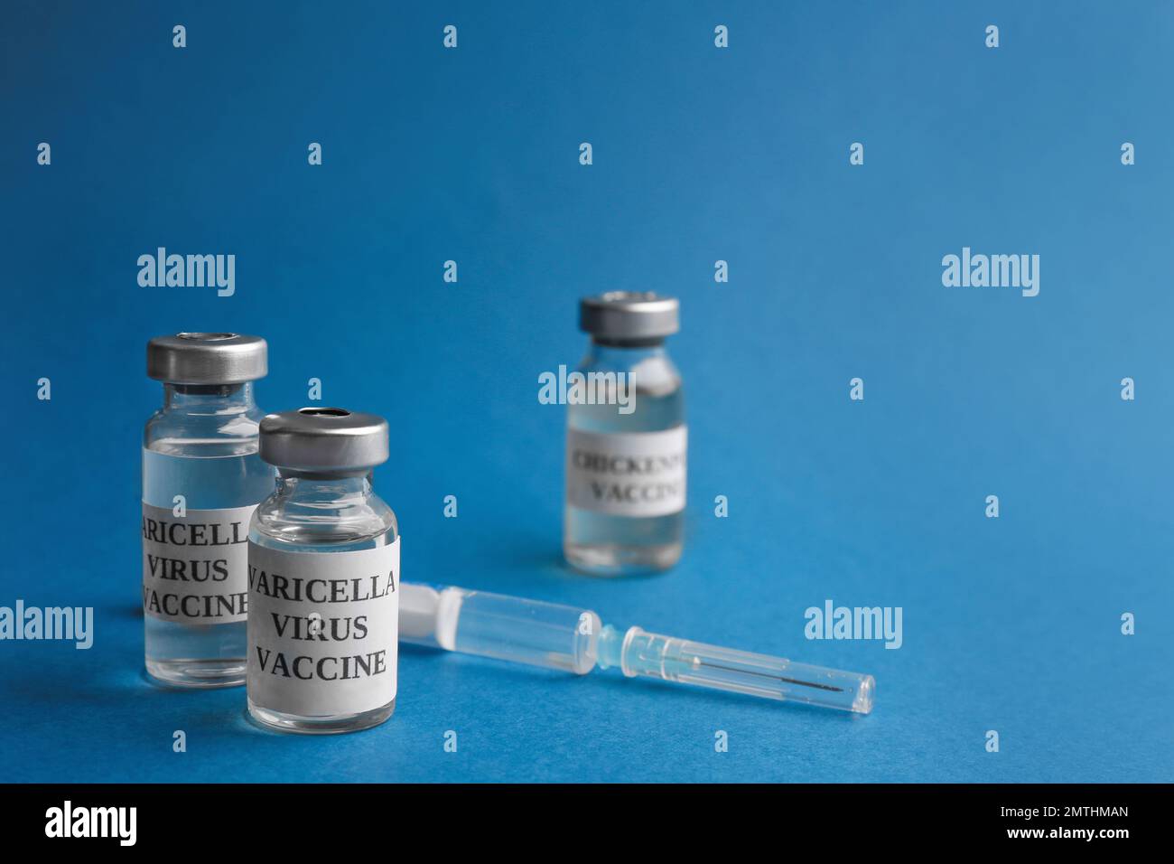 Chickenpox vaccine and syringe on blue background. Varicella virus ...