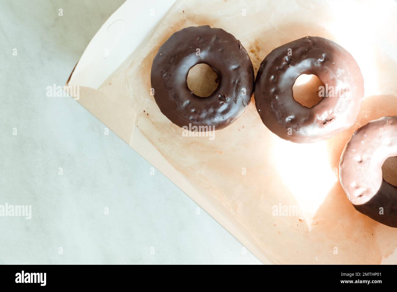 chocolate donuts in an open box, top view Stock Photo - Alamy