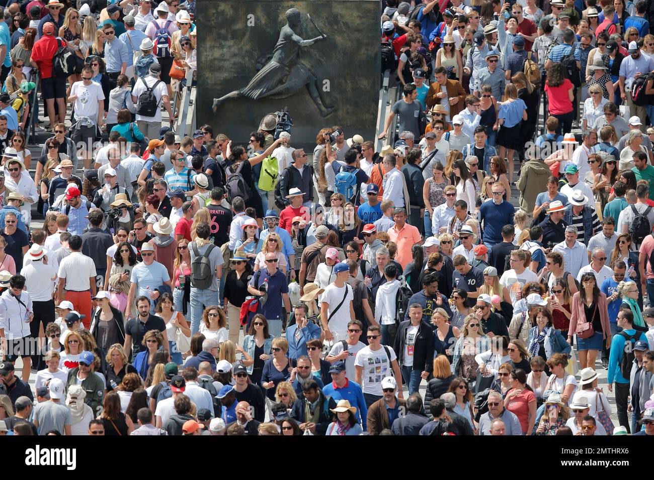 Spectators crowd around a bronze plaque of French tennis player Suzanne ...