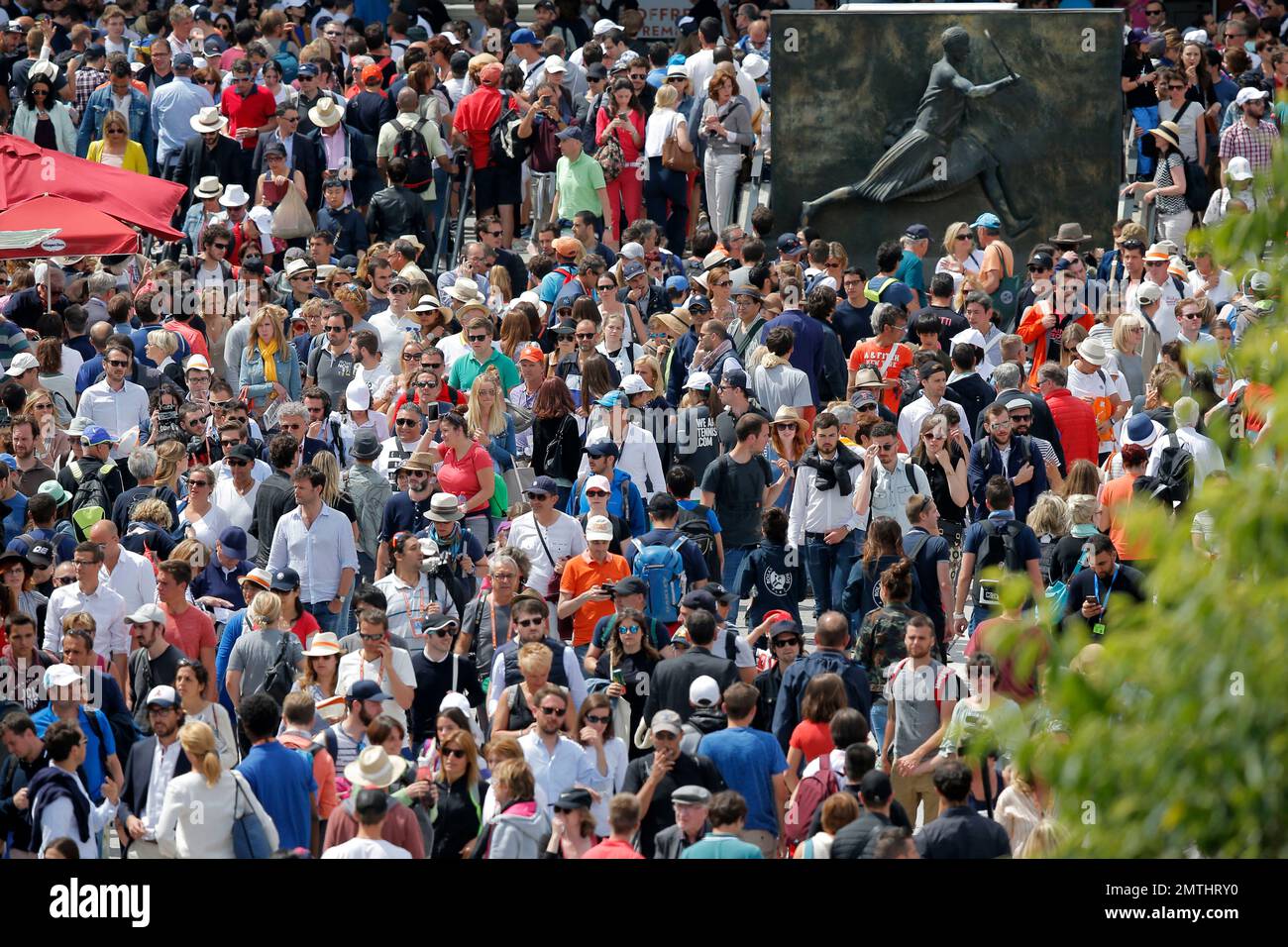Spectators crowd around a bronze plaque of French tennis player Suzanne ...
