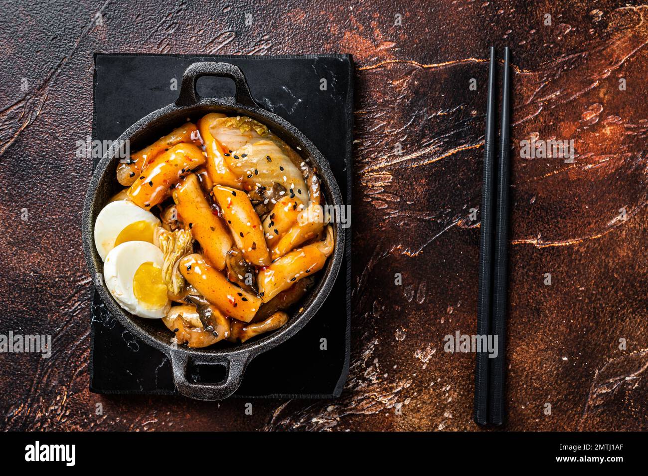 Korean Topokki or Tteokbokki rice cake with egg and mashrooms. Dark ...