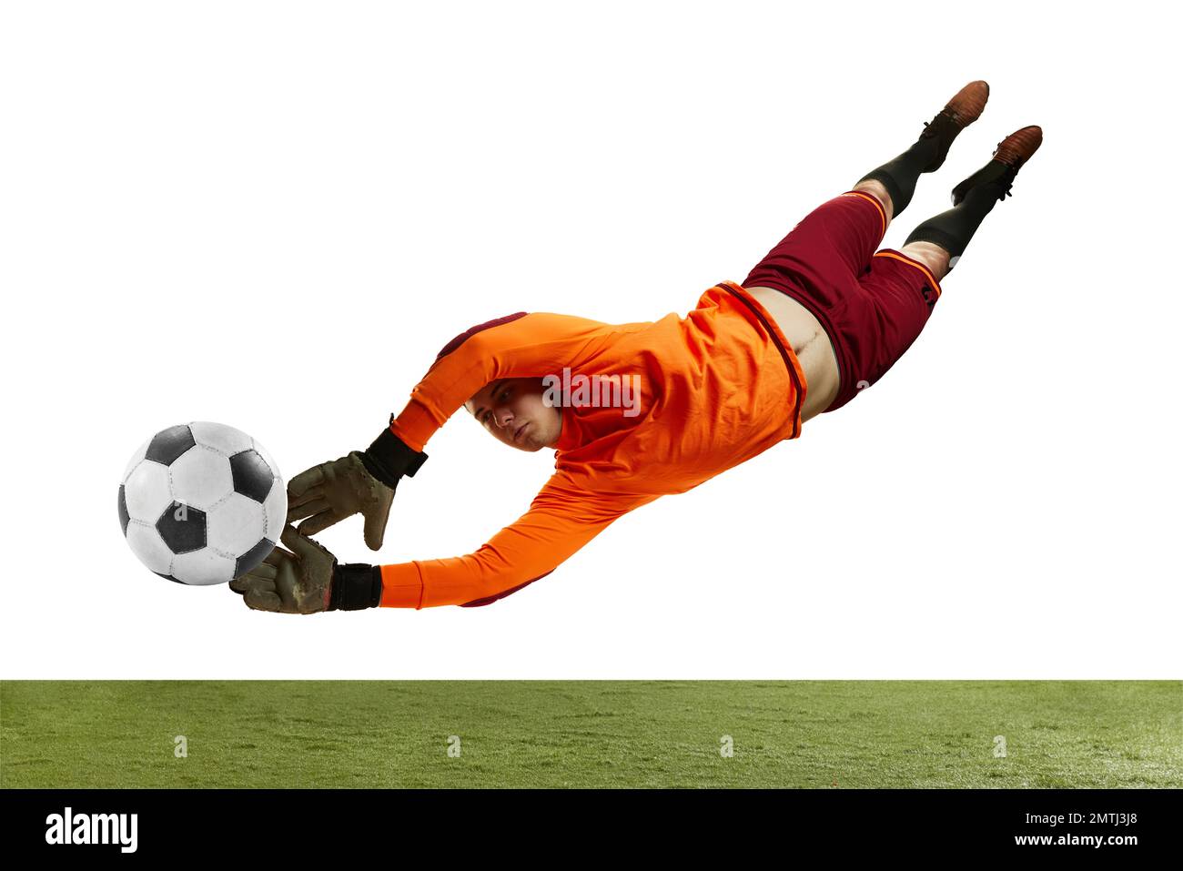 Young man, soccer football goalkeeper catches ball in jump isolated ...