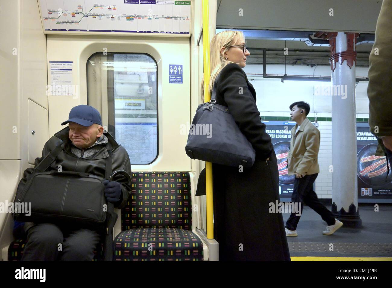 London, England, UK. London Underground: young woman and older man in a ...