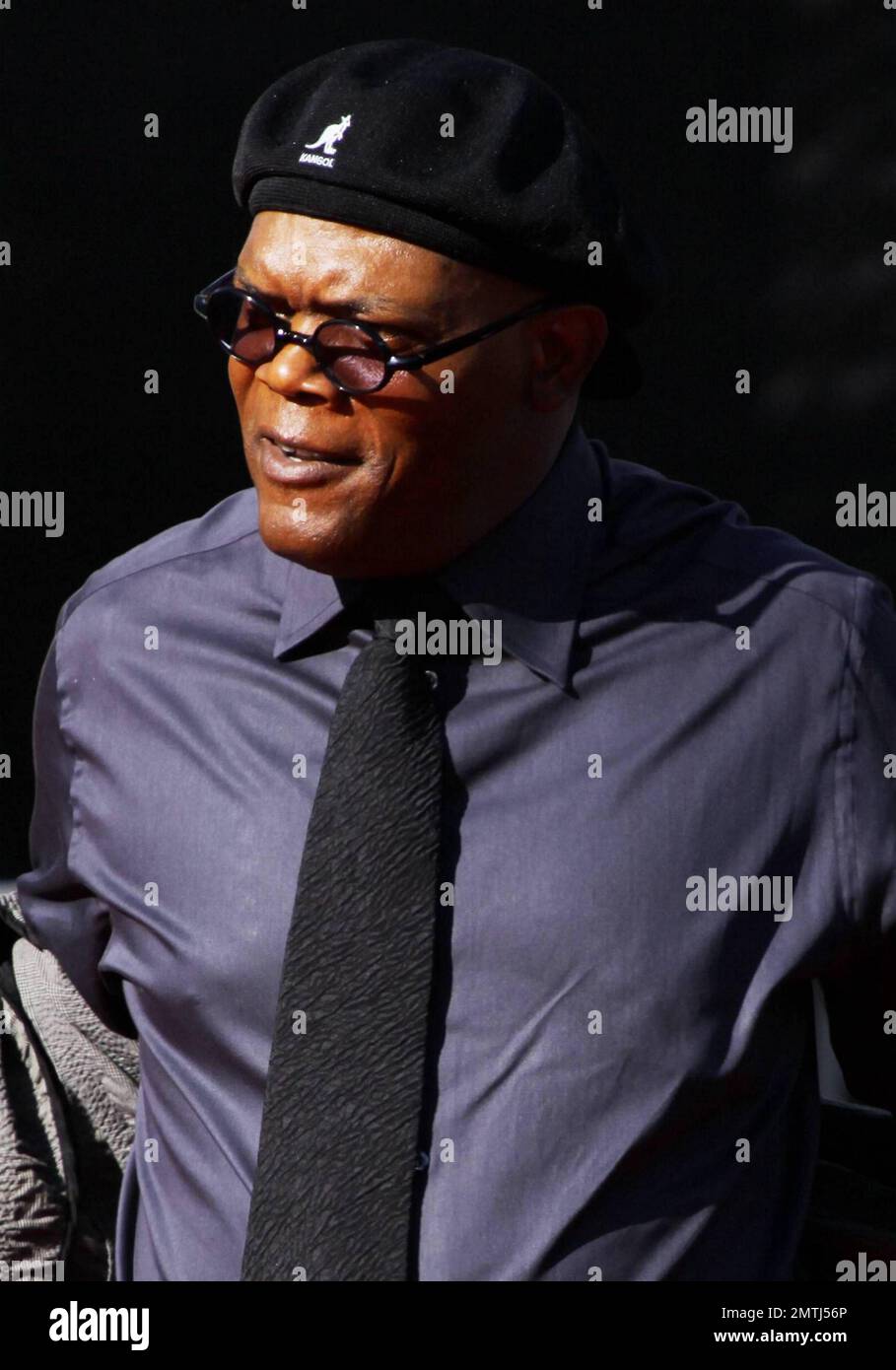 Actor Samuel L. Jackson puts his jacket on after getting out of a black ...