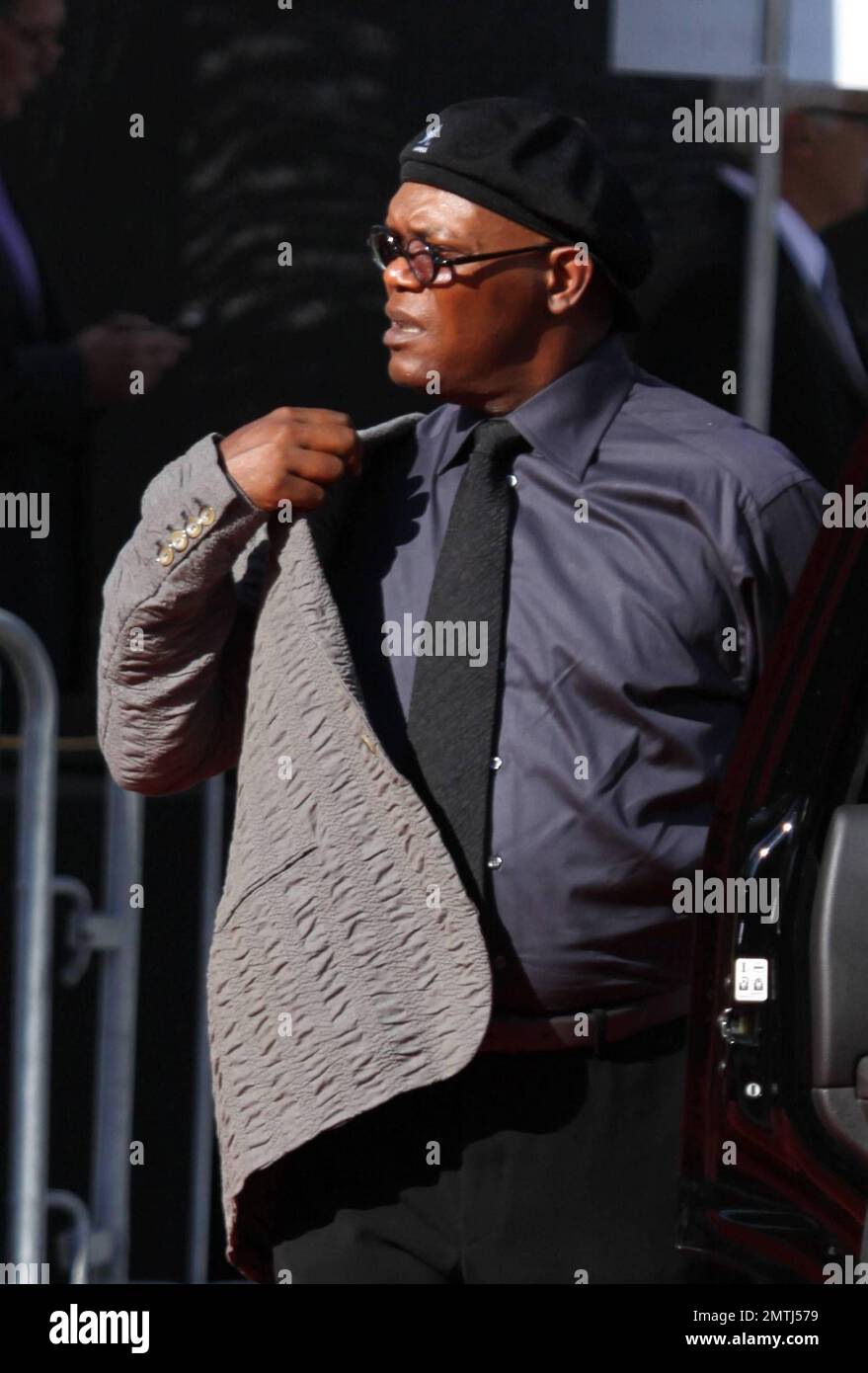 Actor Samuel L. Jackson puts his jacket on after getting out of a black ...