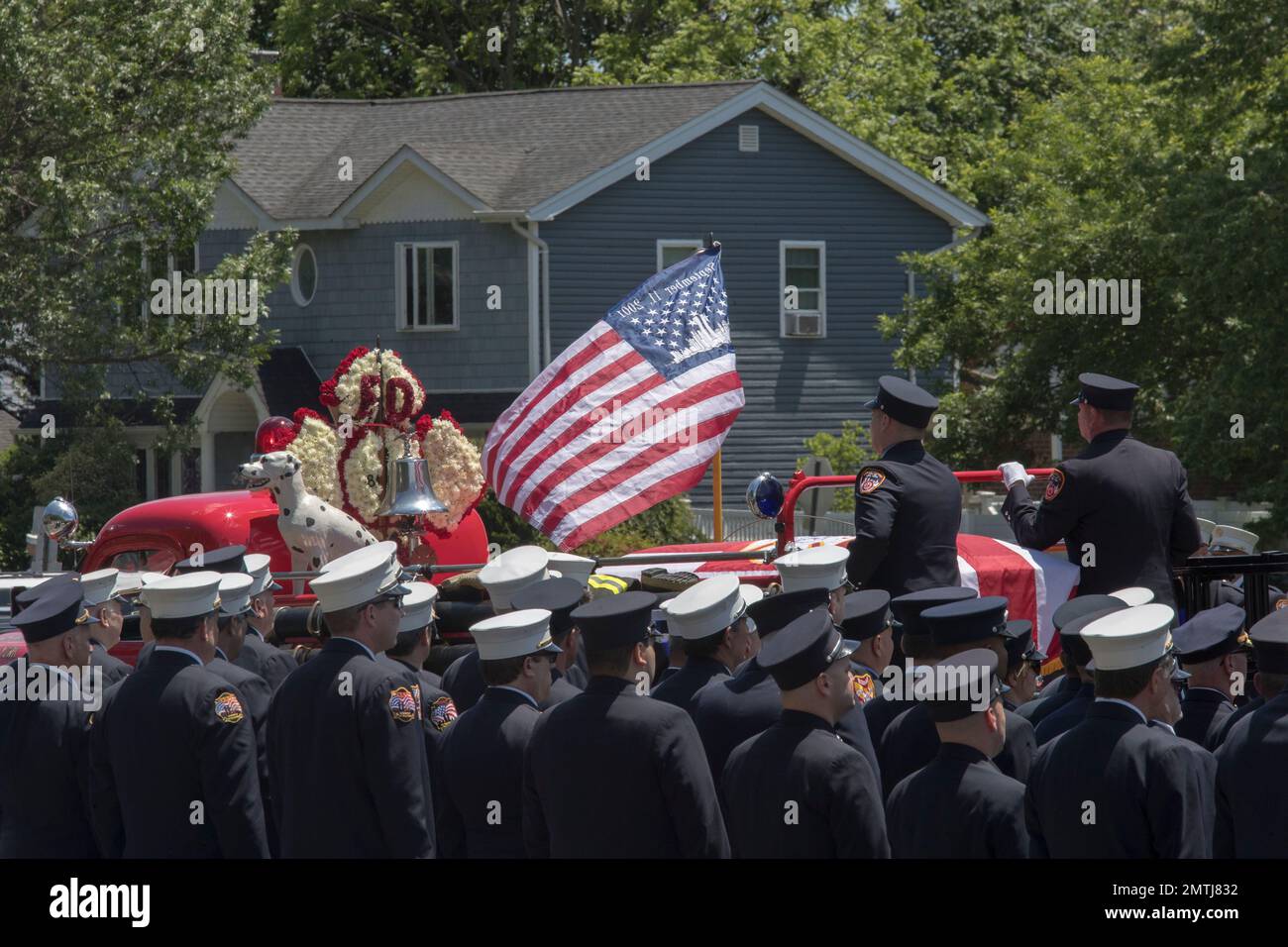 Firefighters stand at attention as the firetruck carrying the coffin of ...