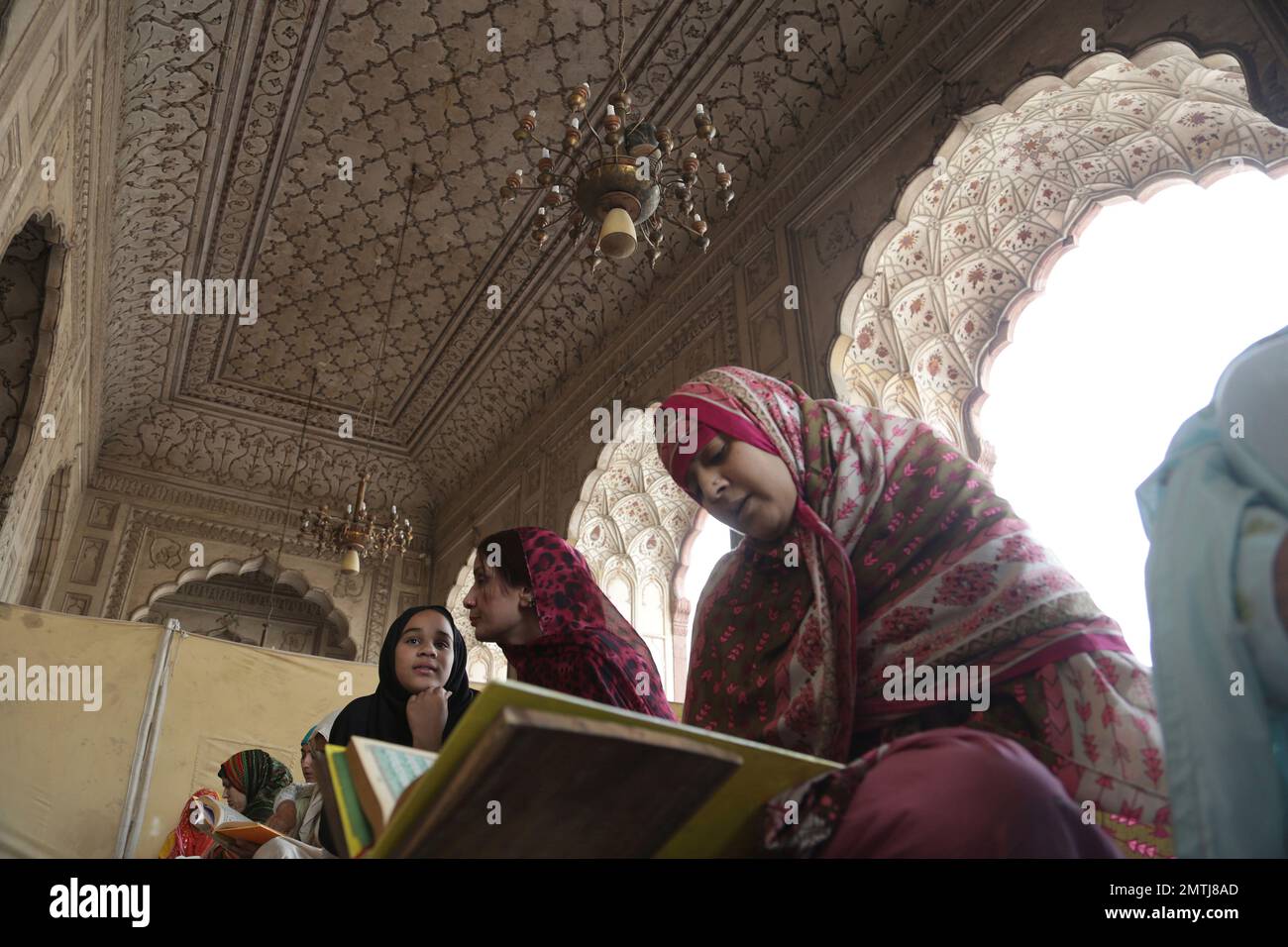 Pakistani Muslims recite the holy Quran in the Badshahi Mosque during ...