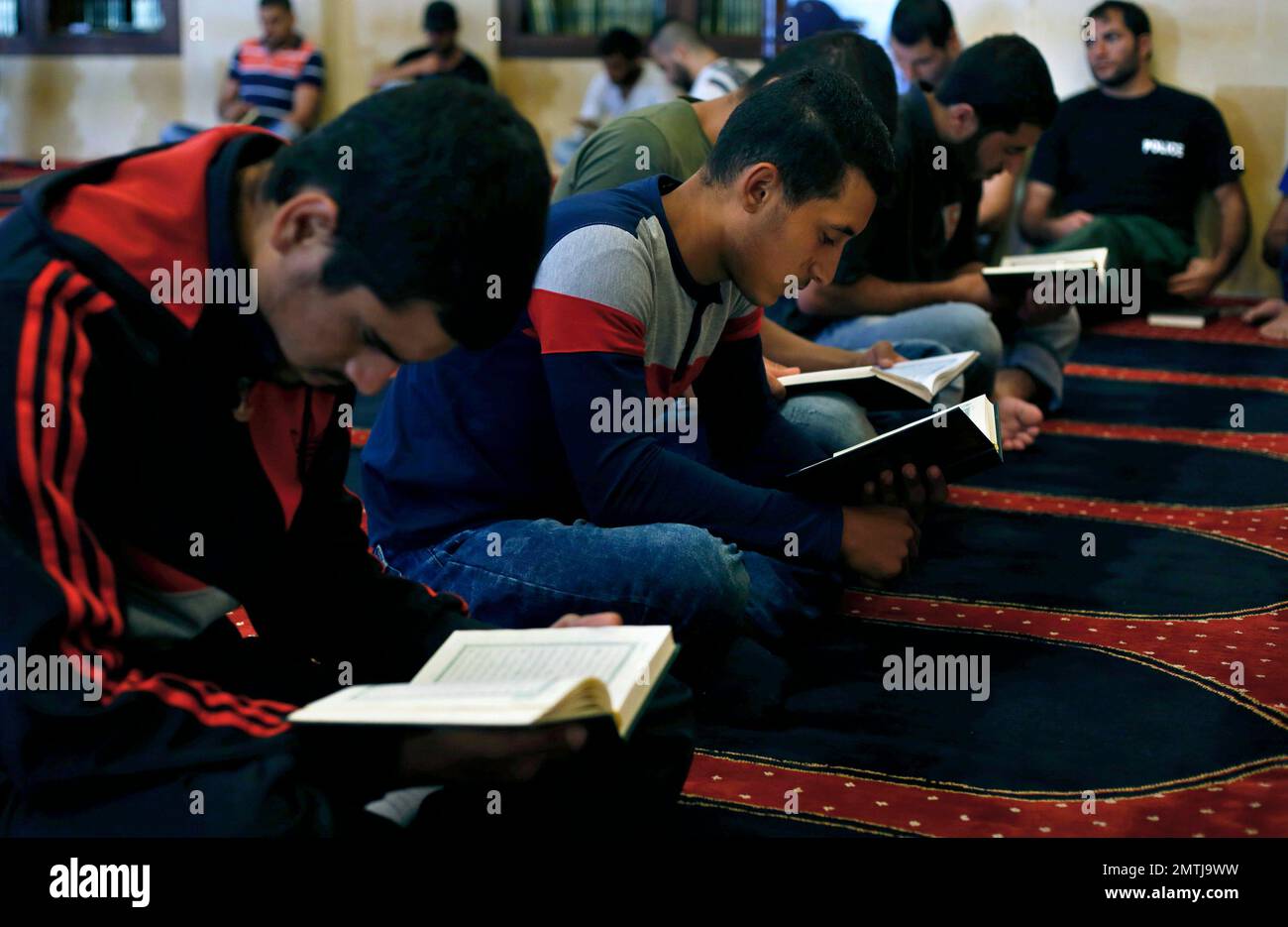 Muslims read a Quran, the Muslim holy book on the first Friday of the ...