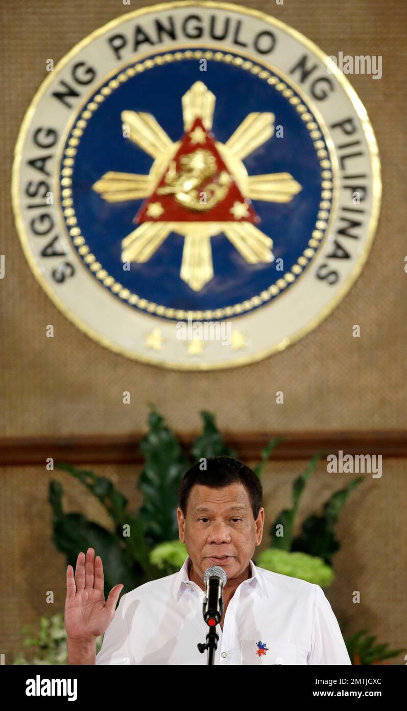 Philippine President Rodrigo Duterte raises his hands as he officiates ...