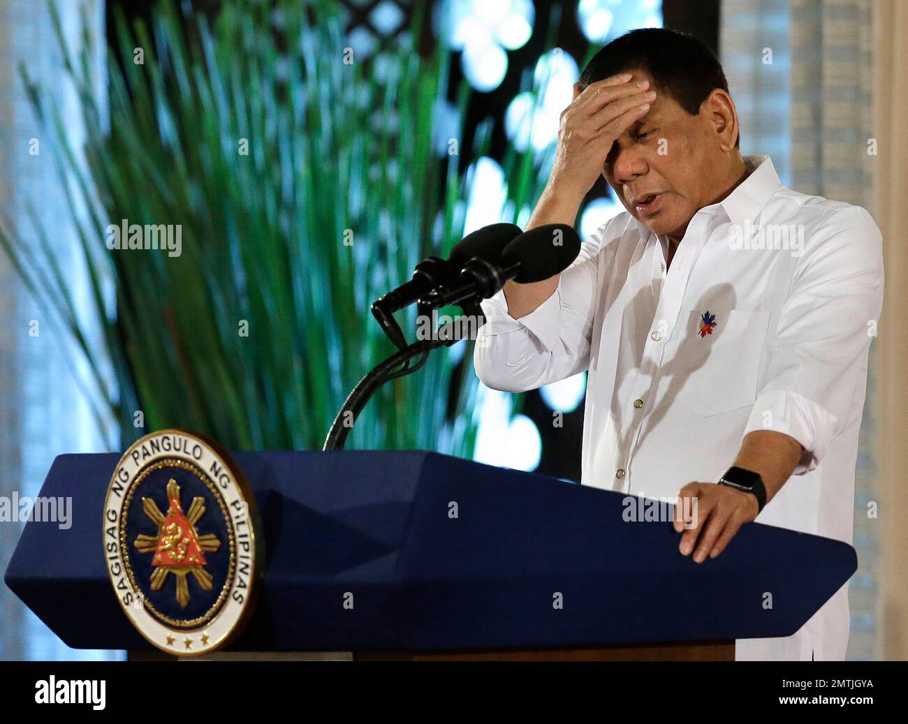 Philippine President Rodrigo Duterte touches his head during his speech ...
