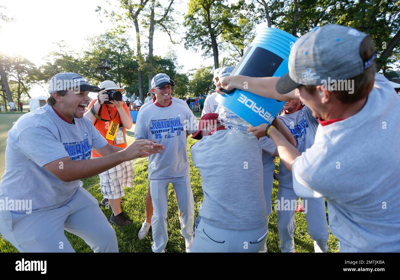Oklahoma men's golf team douse head coach Ryan Hybl as they celebrate ...