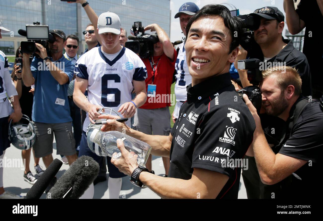 Indy 500 winner Takuma Sato of Japan autographes a milk bottle while ...