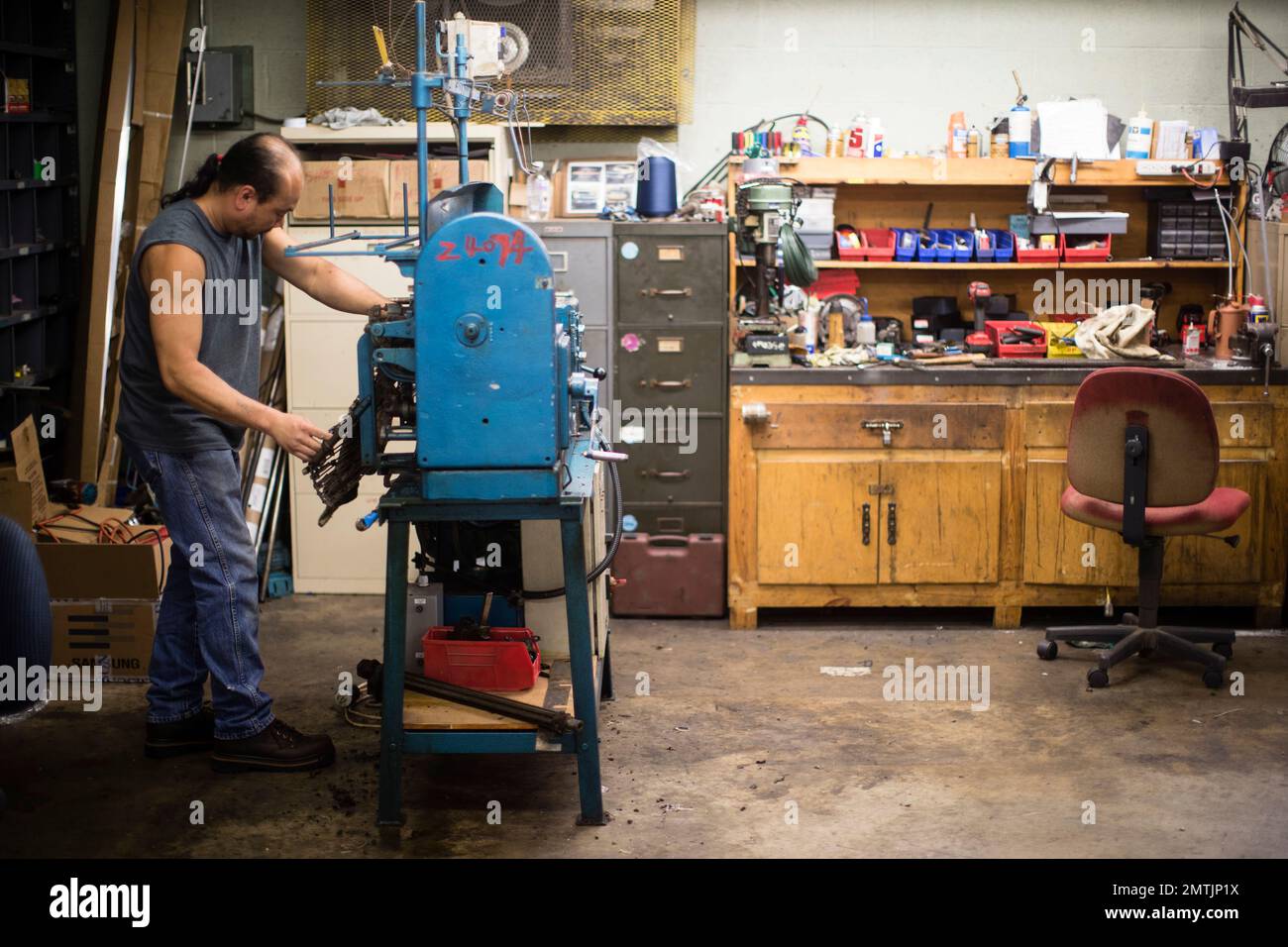 Hien Nguyen works on a knitting machine used in the manufacturing of ...