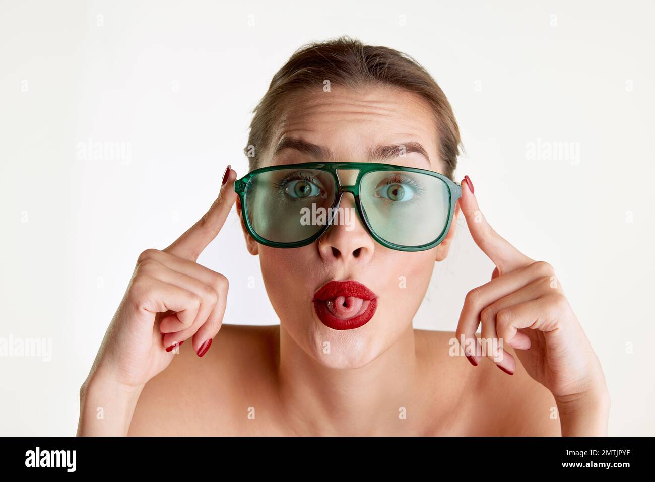 Grimace face. Young beautiful brunette girl with red lips posing in ...