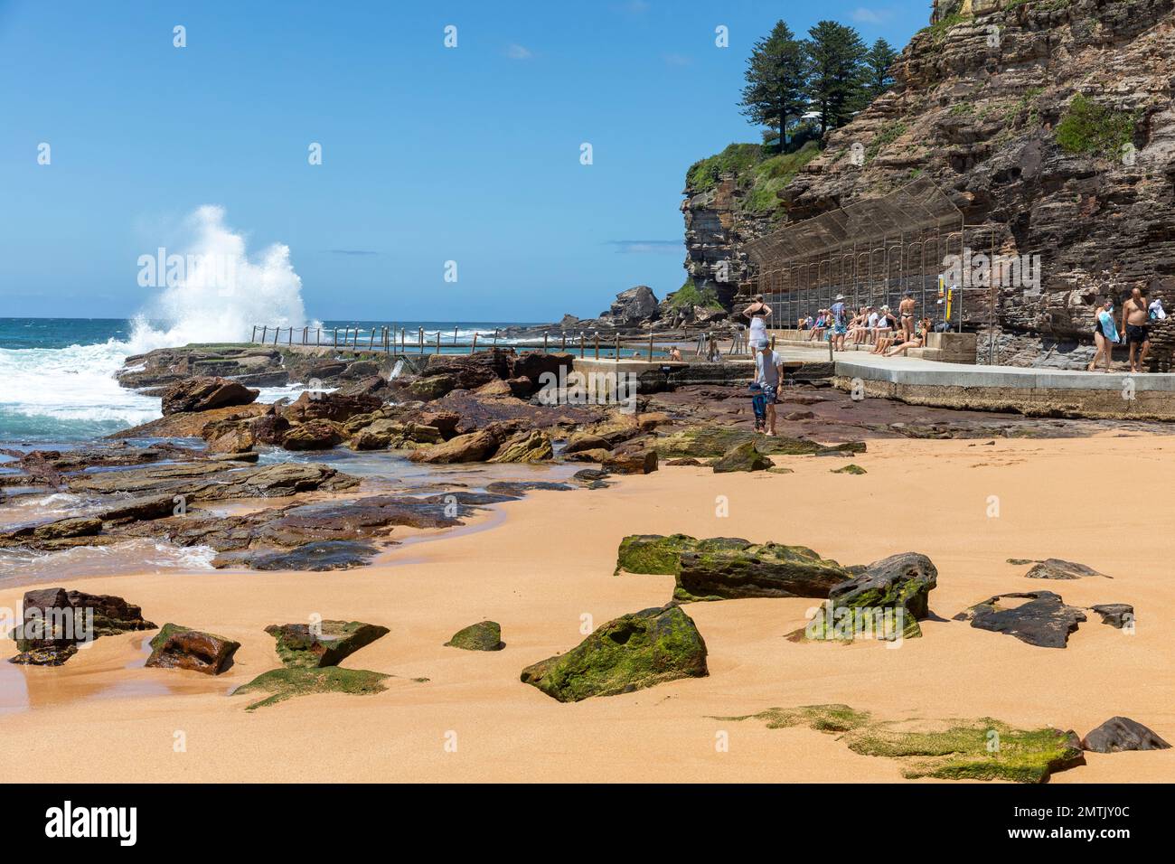 Avalon Beach Sydney with swimmers sitting around the ocean beach rock ...