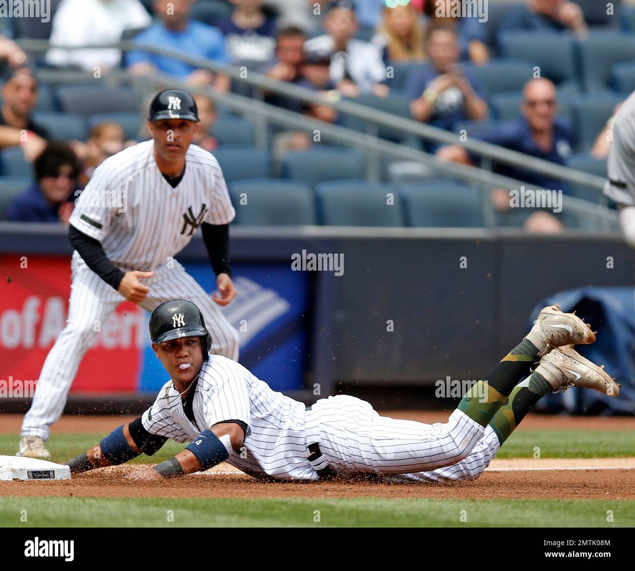 New York Yankees Starlin Castro, below, blows a bubble while sliding ...