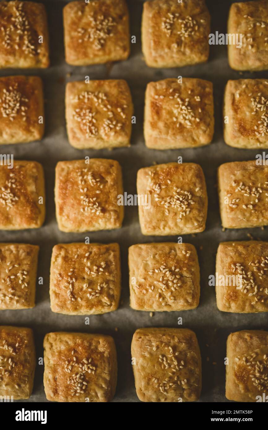 A vertical top-view of homemade sesame scones placed on a flat surface ...