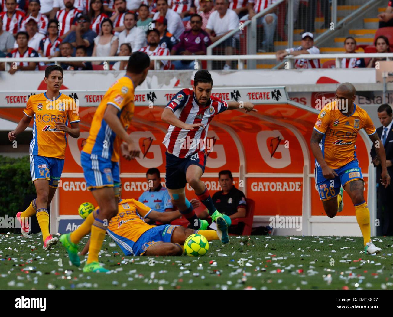 Chivas' Alejandro Zendejas, center fights for the ball with Tigres ...