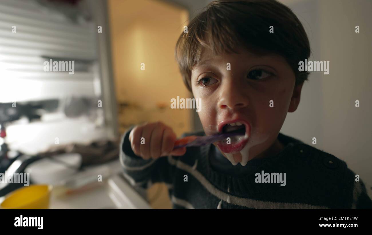 Child brushing teeth with toothbrush at night routine before bed. One ...