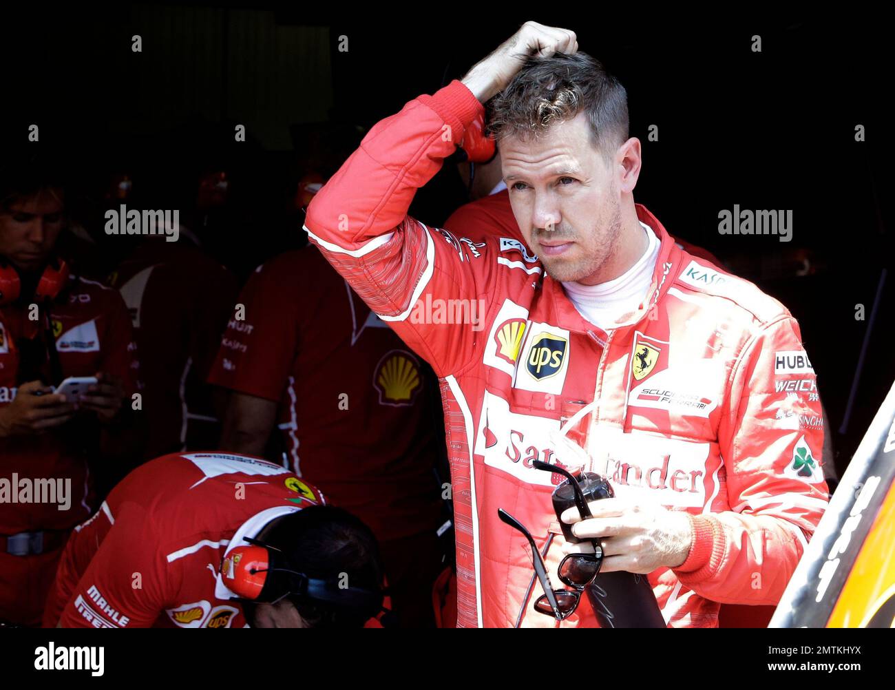 Ferrari driver Sebastian Vettel of Germany adjusts his hair following ...