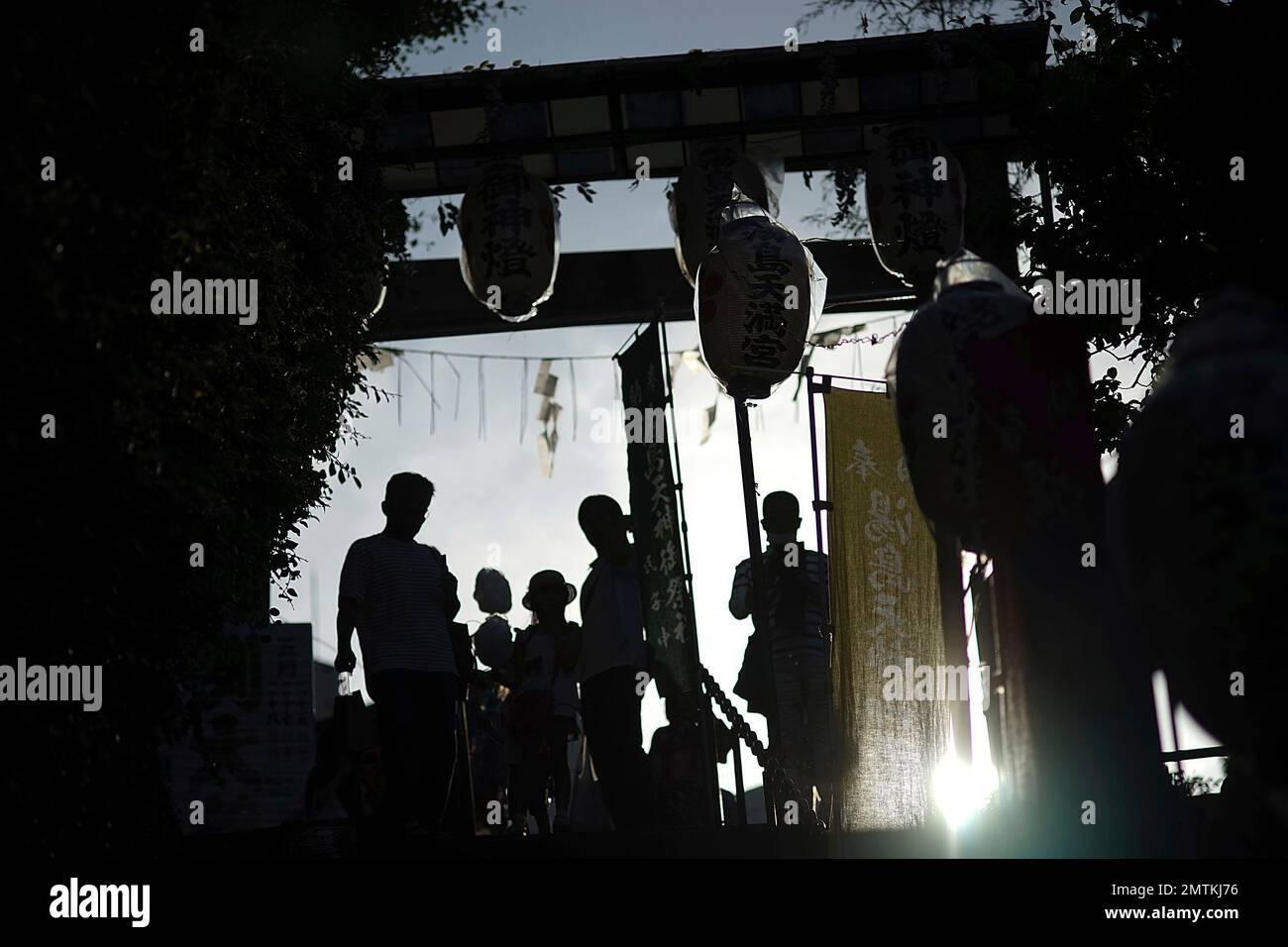 Visitors hang out under a stone shrine gate at Yushima Tenjin Shinto ...