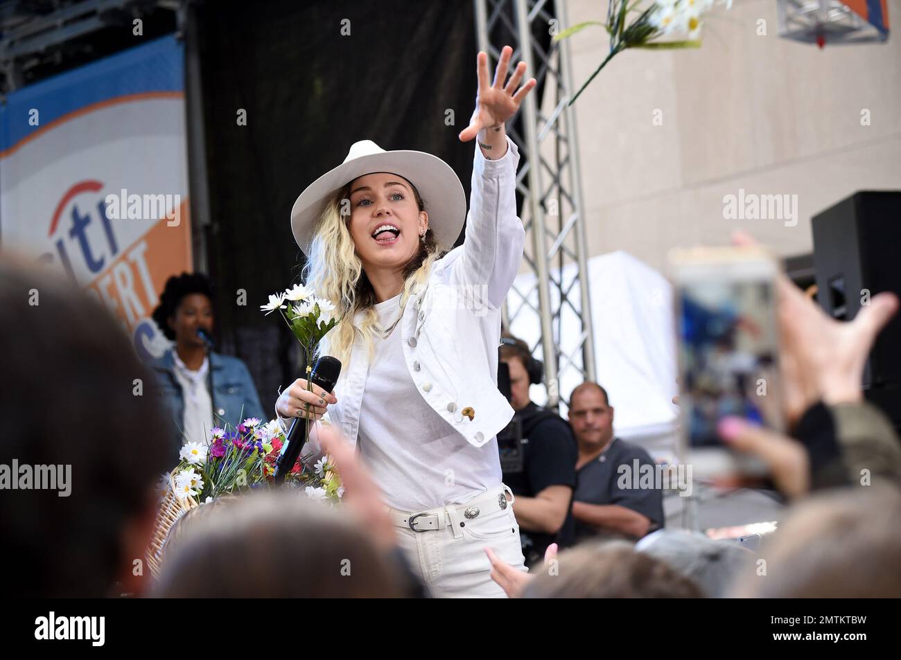 Singer Miley Cyrus tosses flowers to the crowd during her performance ...