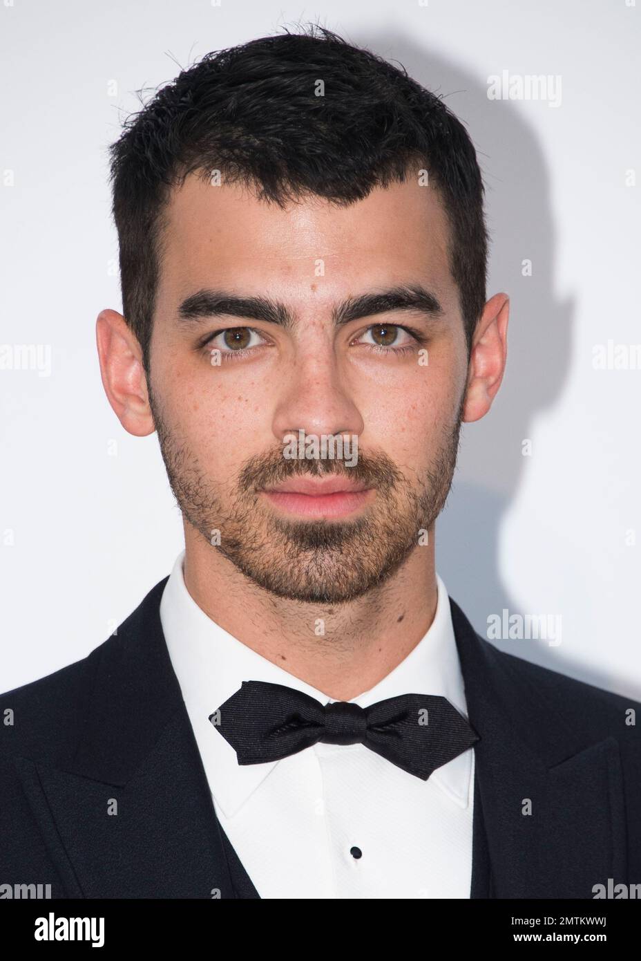 Joe Jonas poses for photographers upon arrival at the amfAR charity ...