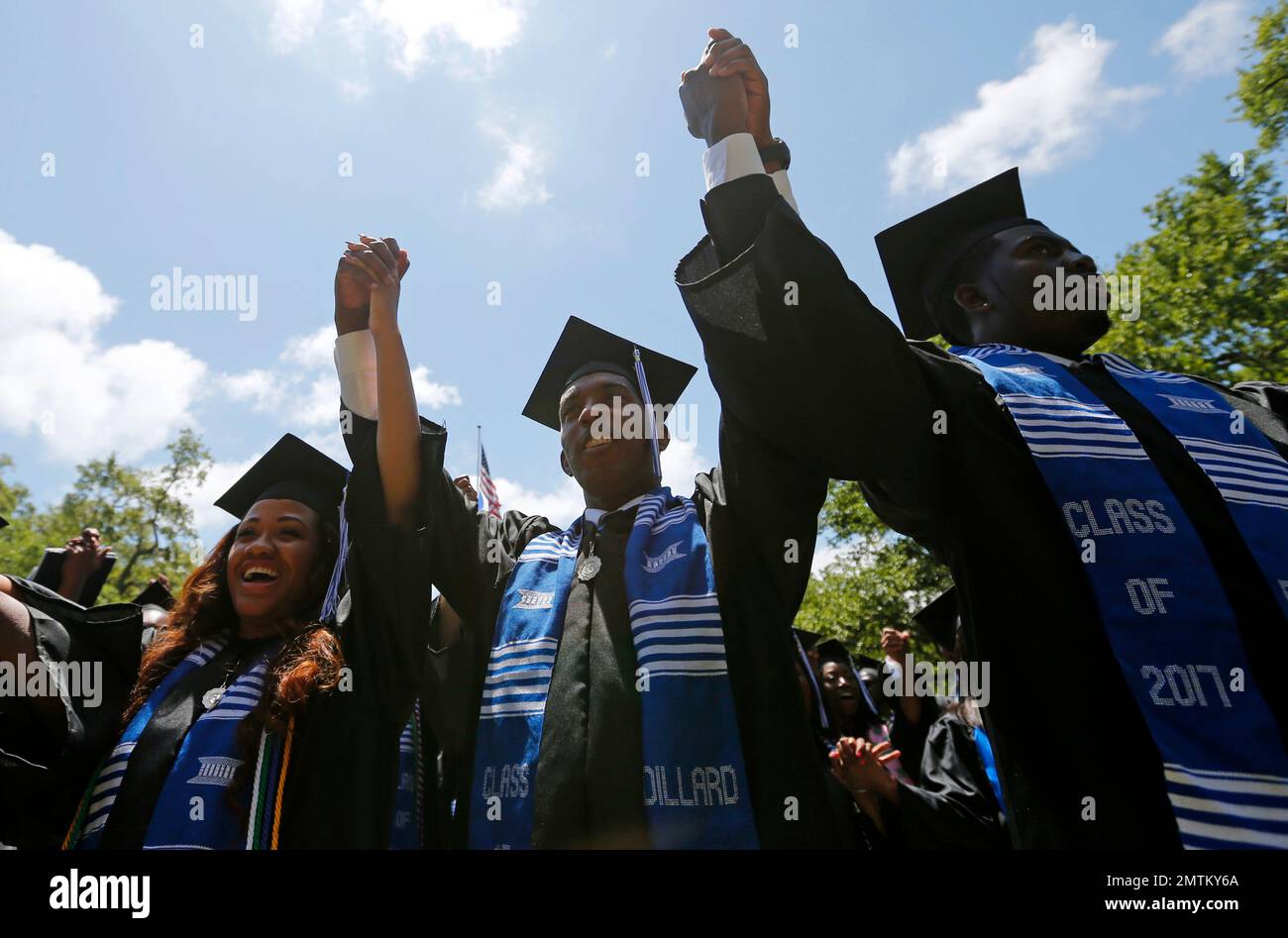 In this Saturday, May 13, 2017 photo, graduates hold up their hands ...